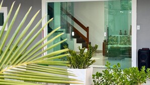 Um interior moderno com escada, portas de vidro e plantas dentro de casa.