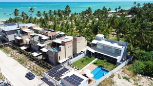 Zona residencial com edifícios modernos, piscina e vista para o oceano.