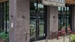 Um café de bem-estar com design moderno, com fachada de vidro e área externa para sentar.