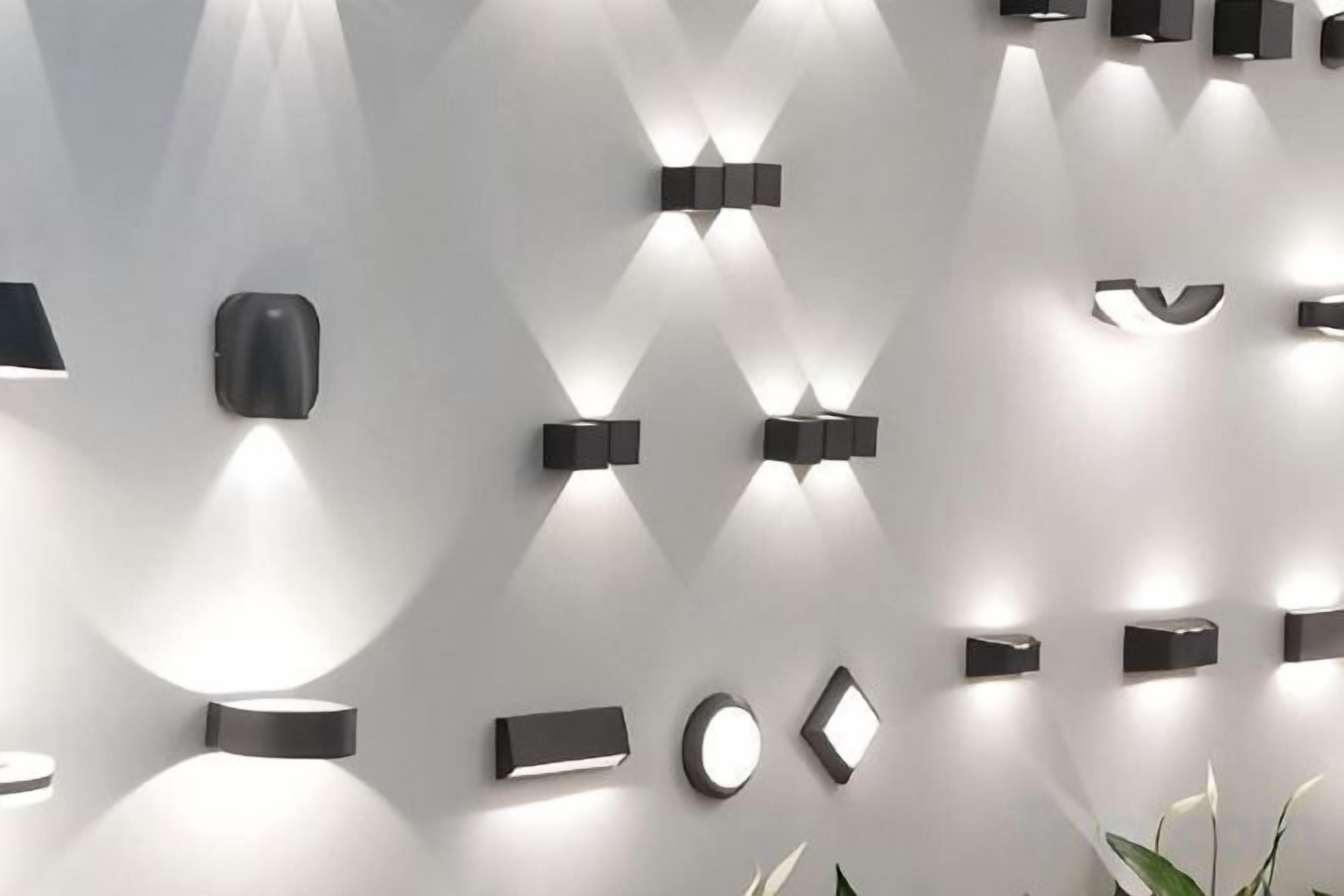 Parede com luminárias de diferentes formatos fixadas.