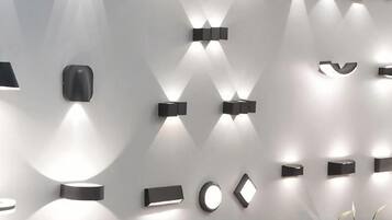 Parede com luminárias de diferentes formatos fixadas.