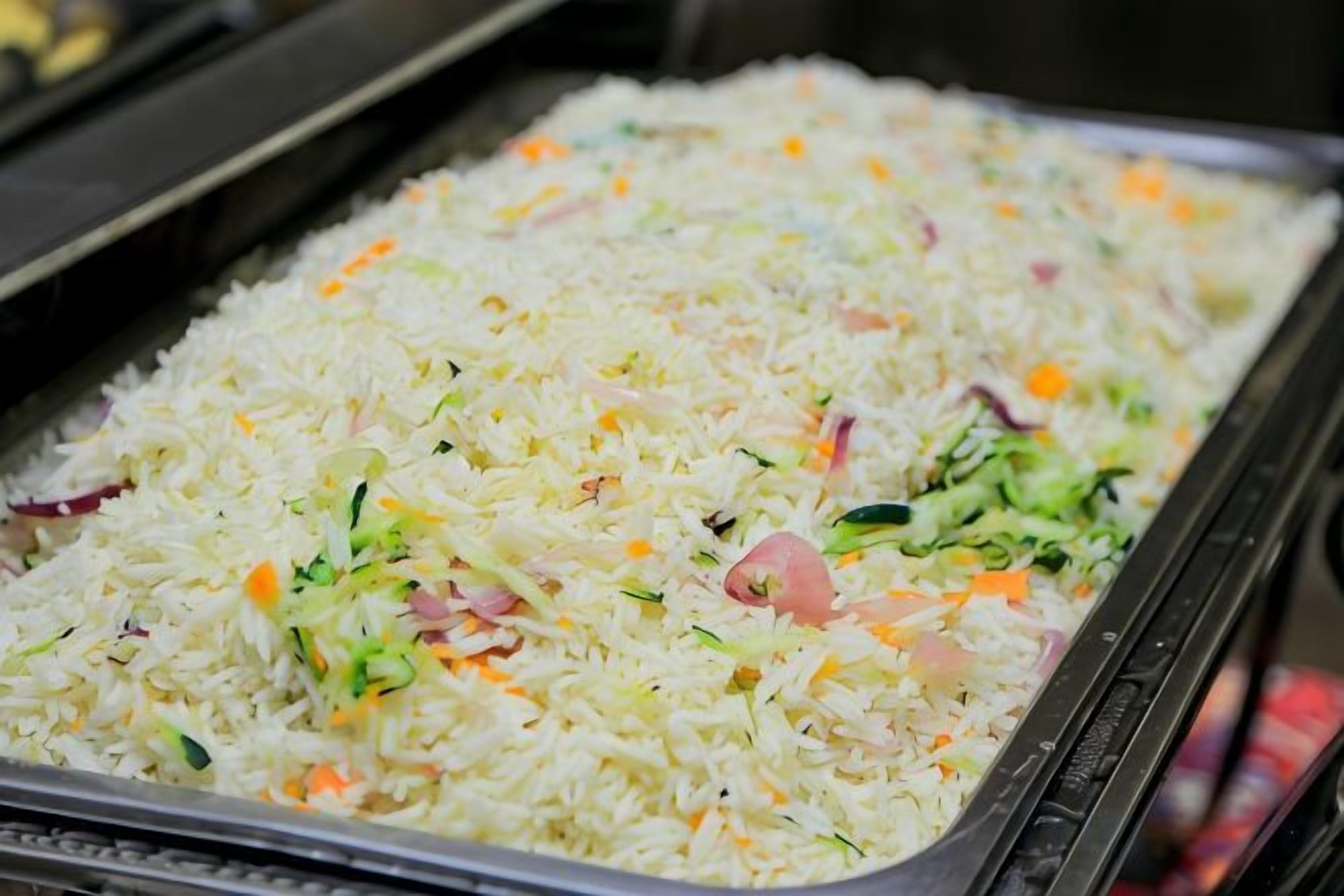 Uma travessa de arroz cozido com legumes.