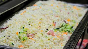 Uma travessa de arroz cozido com legumes.