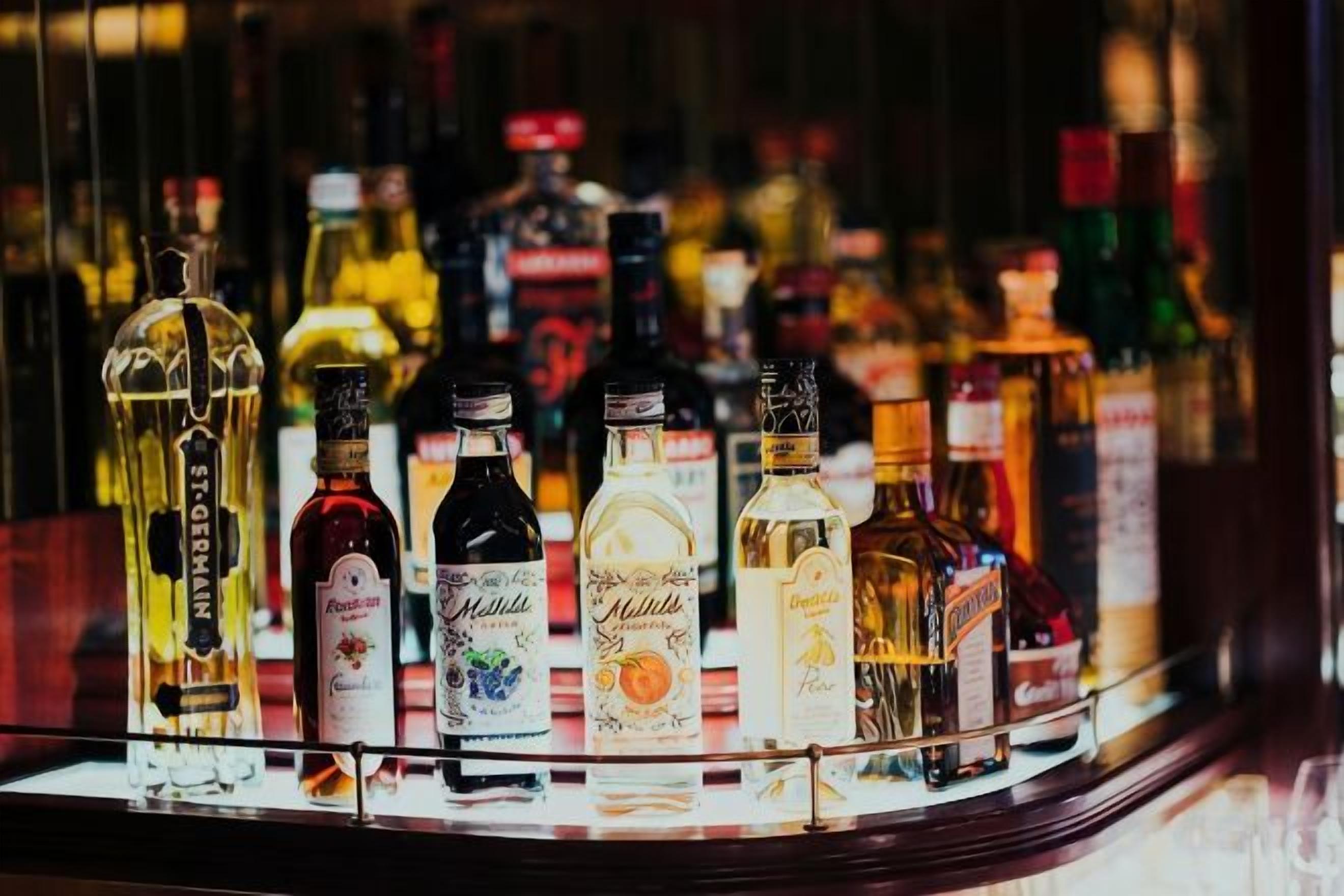 Diversas garrafas de bebidas alcoólicas expostas em um bar.