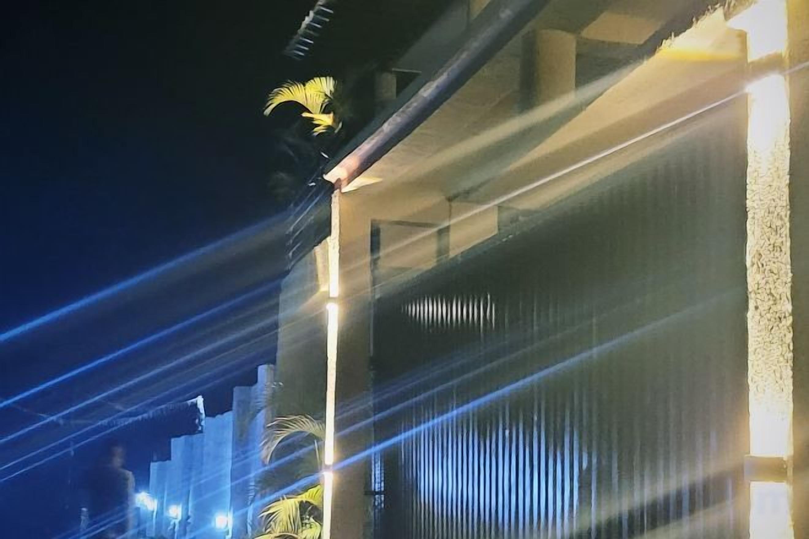 Fachada de edifício com estrutura vertical, possivelmente um muro ou pilar, e um elemento horizontal que pode ser uma janela ou porta.