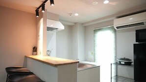 Cozinha moderna com espaço para bar, eletrodomésticos embutidos e janela que proporciona iluminação natural.