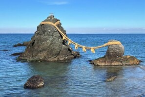 Uma ponte de corda sobre uma ilha rochosa em um corpo d'água.