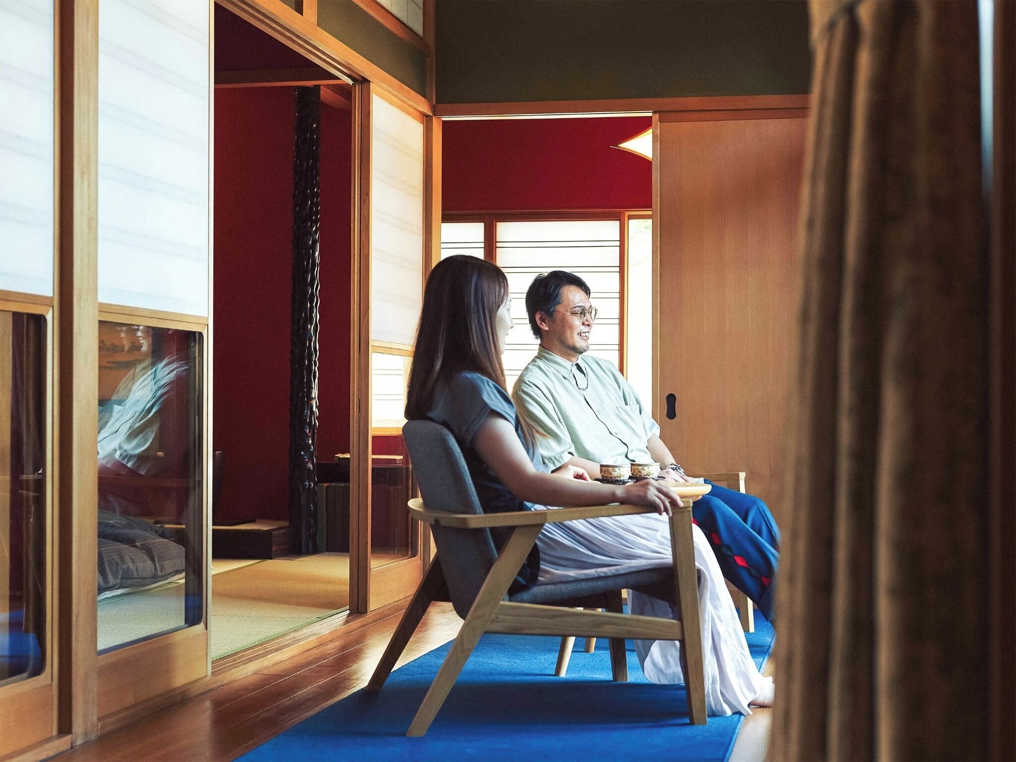 Um quarto japonês tradicional com piso de tatame, uma mesa de madeira baixa e uma porta deslizante.