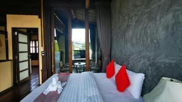 Quarto de hotel com cama, mesa e vista para o exterior.