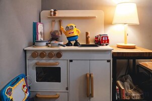 Uma cozinha com fogão, um boneco Minion e uma luminária.