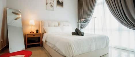 Quarto de hotel moderno com uma cama, mesas de cabeceira, luminária, espelho e obras de arte na parede.