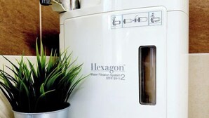Sistema de filtragem de água com uma planta ao lado.