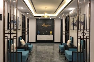 Um interior moderno com área de estar central, arte decorativa nas paredes e piso estampado.