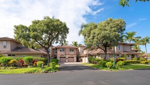 Um bairro residencial com várias casas de dois andares, cada uma com garagem, cercado por jardins e árvores bem cuidados.