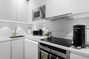 Um frigorífico, um micro-ondas, um forno, uma placa de cozinha 