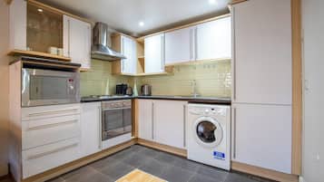 Um frigorífico, um micro-ondas, um forno, uma placa de cozinha