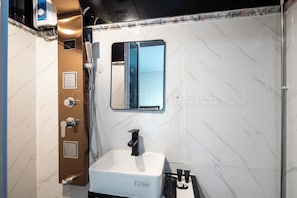 Quarto Twin Deluxe, Vista para a cidade | Casa de banho | Um polibã, artigos de higiene pessoal grátis, um secador de cabelo 