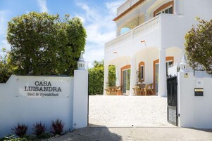 Um edifício branco com uma placa que diz 'CASA LUISANDRA Bed & Breakfast'.