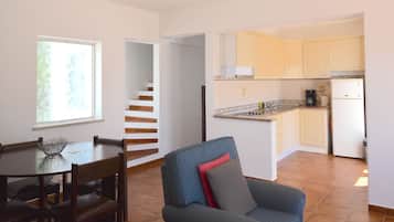 Um apartamento moderno com área de jantar, sala de estar e cozinha.