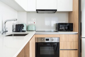 Apartamento, 2 quartos, cozinha, Vista para a cidade | Cozinha privada | Um frigorífico/congelador grande, um micro-ondas, um forno 