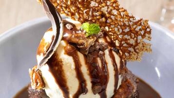 Sobremesa com bolo de chocolate, gelado e molho de caramelo.