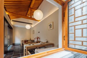Um quarto em estilo tradicional japonês, com tatames, vigas de madeira e porta de shoji.