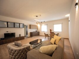Suite Júnior, vista para o jardim | Sala de estar | Smart TV de 55 polegadas com canais digitais, Netflix 