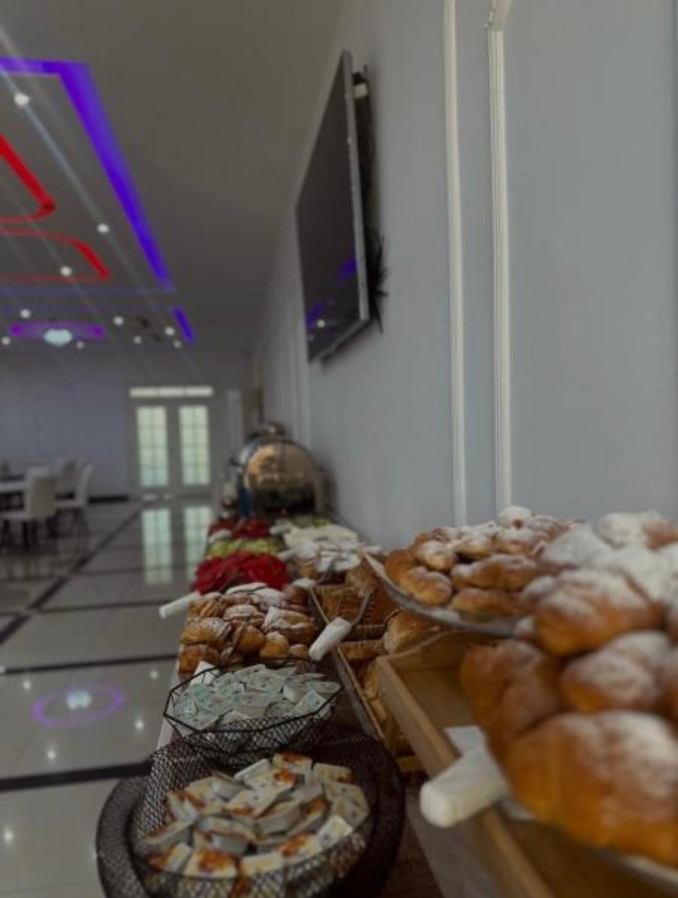 Disposição de buffet com diversos pães e doces.