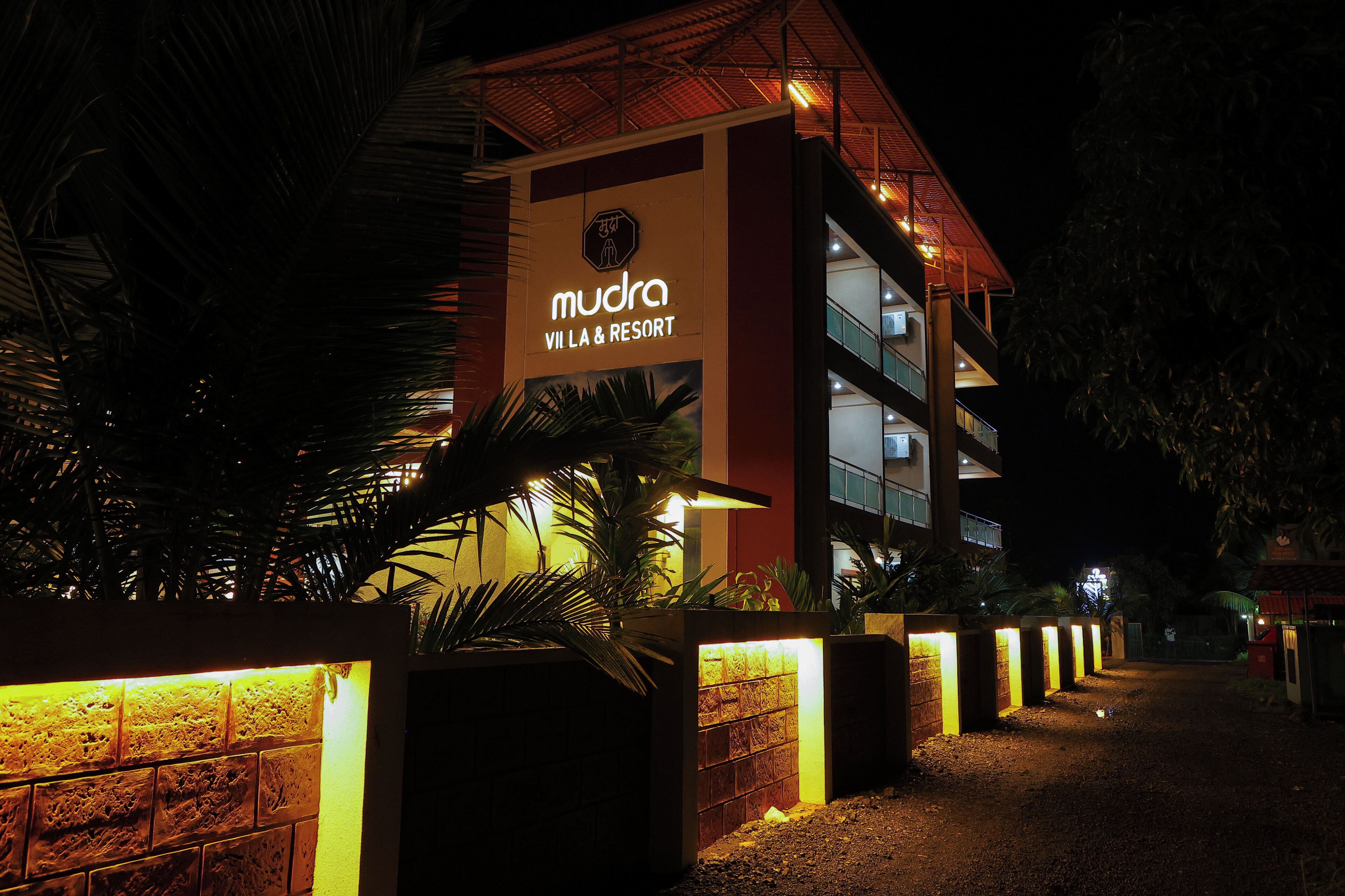 Um edifício de vários andares com uma placa que diz 'mudra villa & resort'.