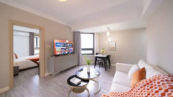 Apartamento superior, 1 quarto, vista para a cidade | Sala de estar | Smart TV