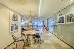 Um interior moderno com uma mesa de jantar redonda, cadeiras de estrutura de arame preta e um lustre.