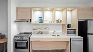 Uma cozinha moderna com eletrodomésticos embutidos, uma pia de aço inoxidável e armários de madeira.