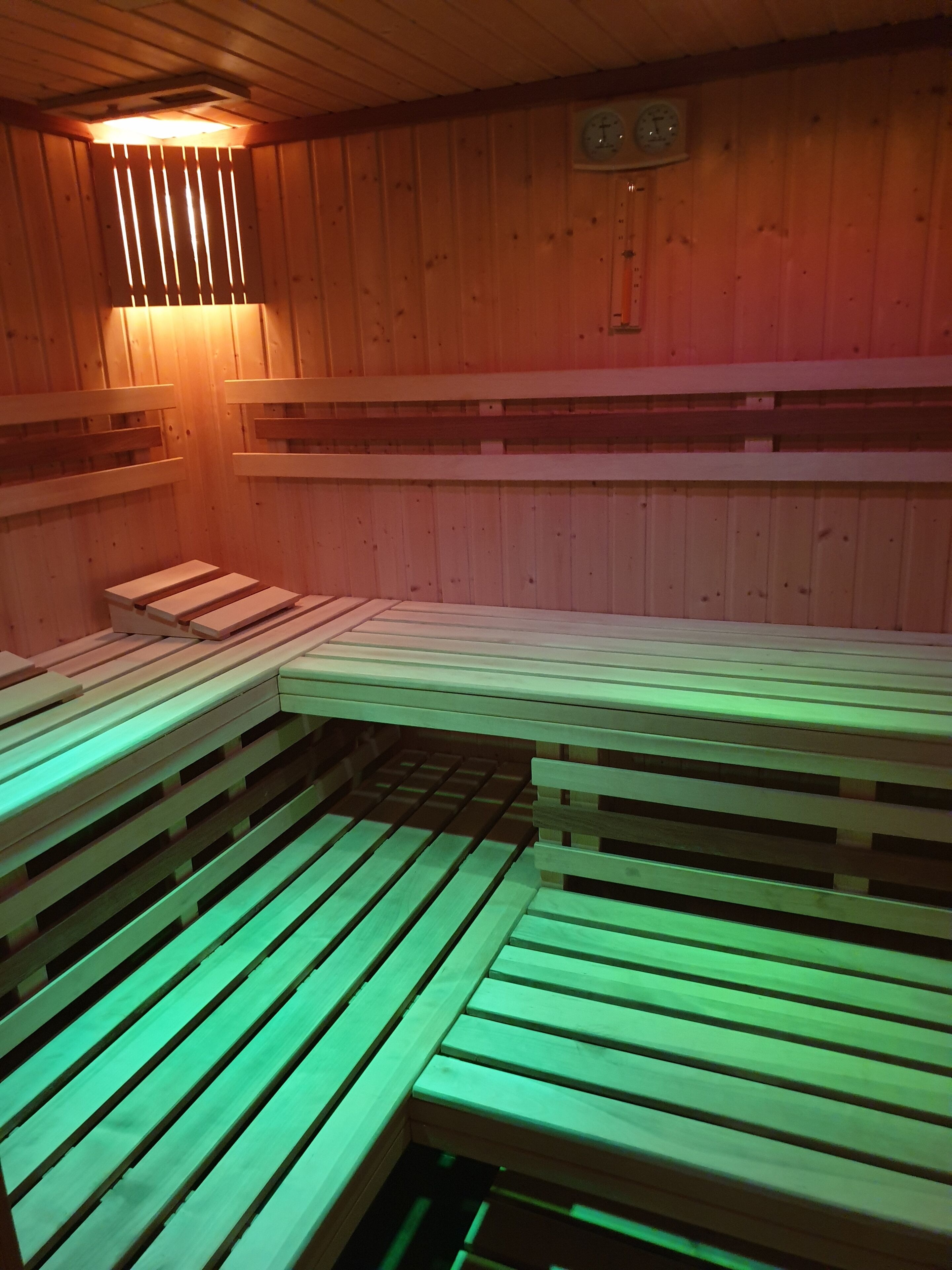 Uma sauna com bancos de madeira e teto inclinado.