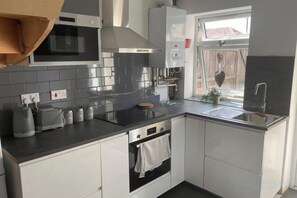 Uma cozinha moderna com micro-ondas, fogão e pia.