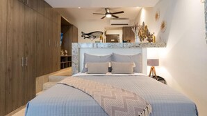Quarto com cama grande, guarda-roupa de madeira e ventoinha no teto.