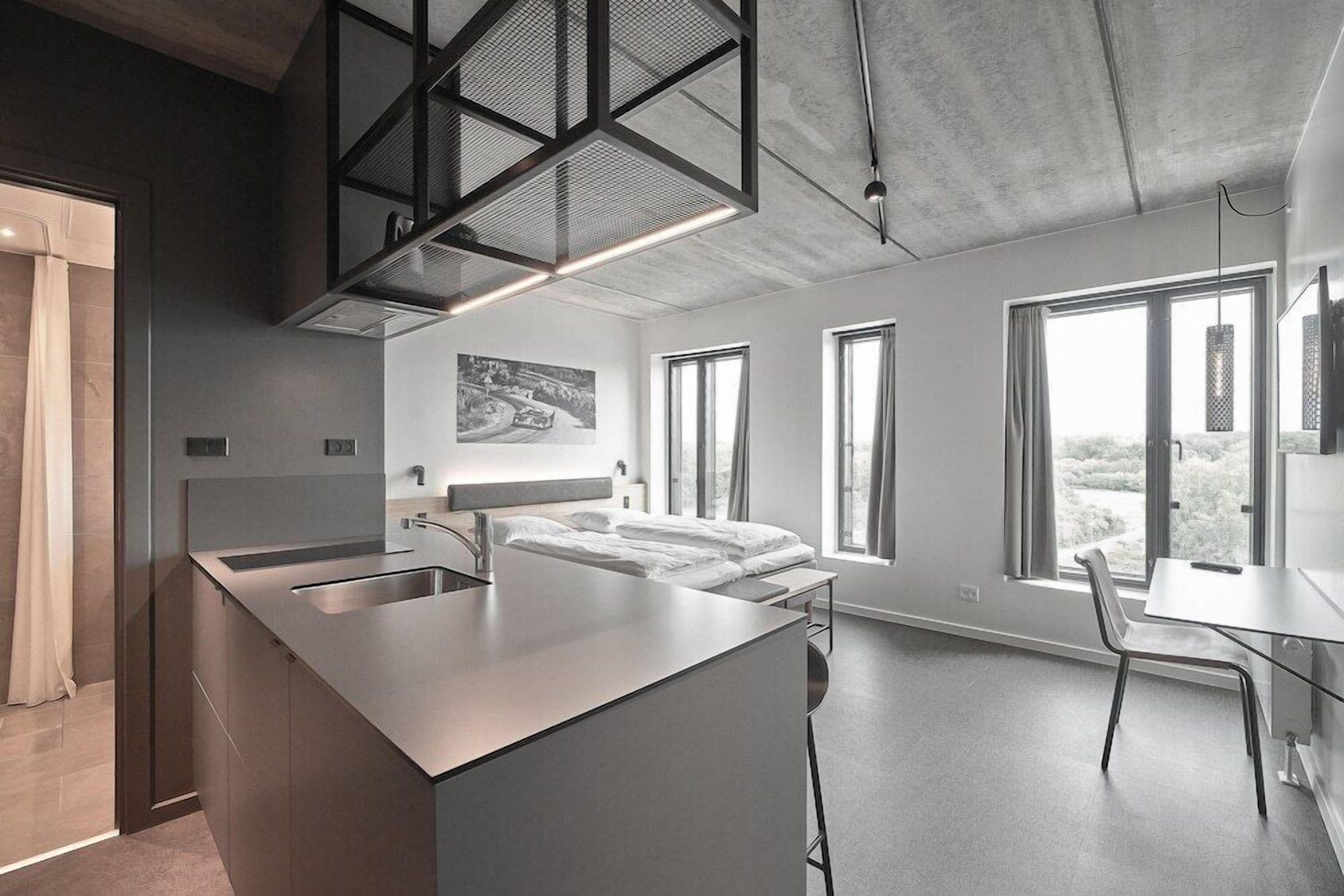 Uma cozinha moderna com uma ilha central, área de jantar com mesa e cadeiras, e amplas janelas com vista.