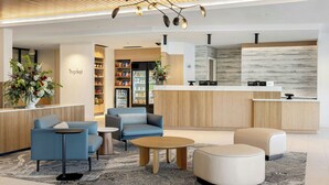 Um lobby moderno com assentos, balcão de recepção e área de cozinha.