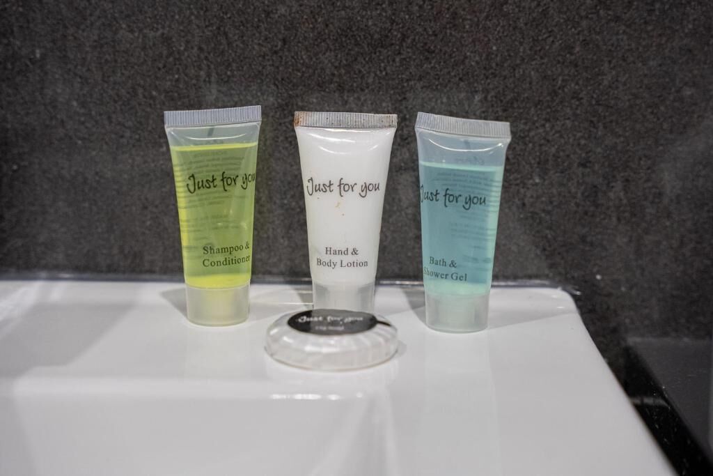 Três embalagens de produtos de higiene pessoal sobre uma superfície branca.