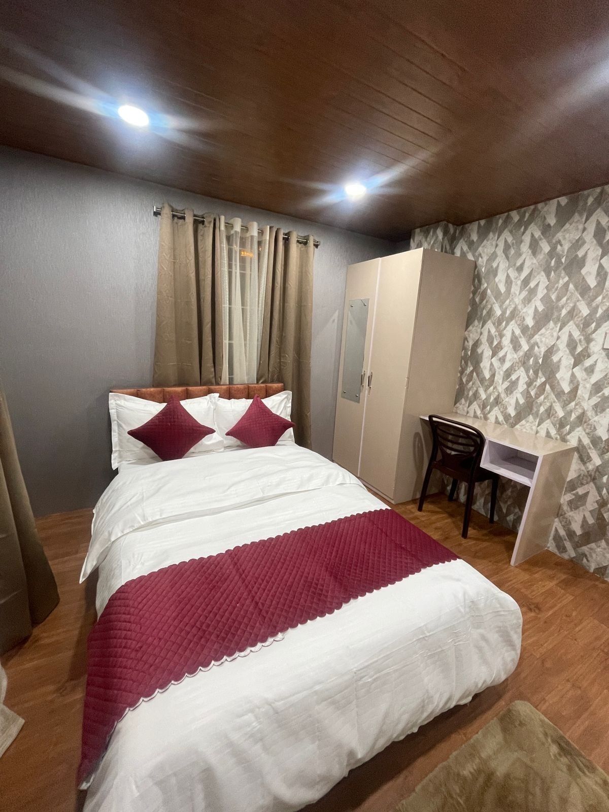 Quarto com cama, escrivaninha e cadeira.