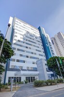 Um edifício de hotel moderno com entrada destacada e céu claro.