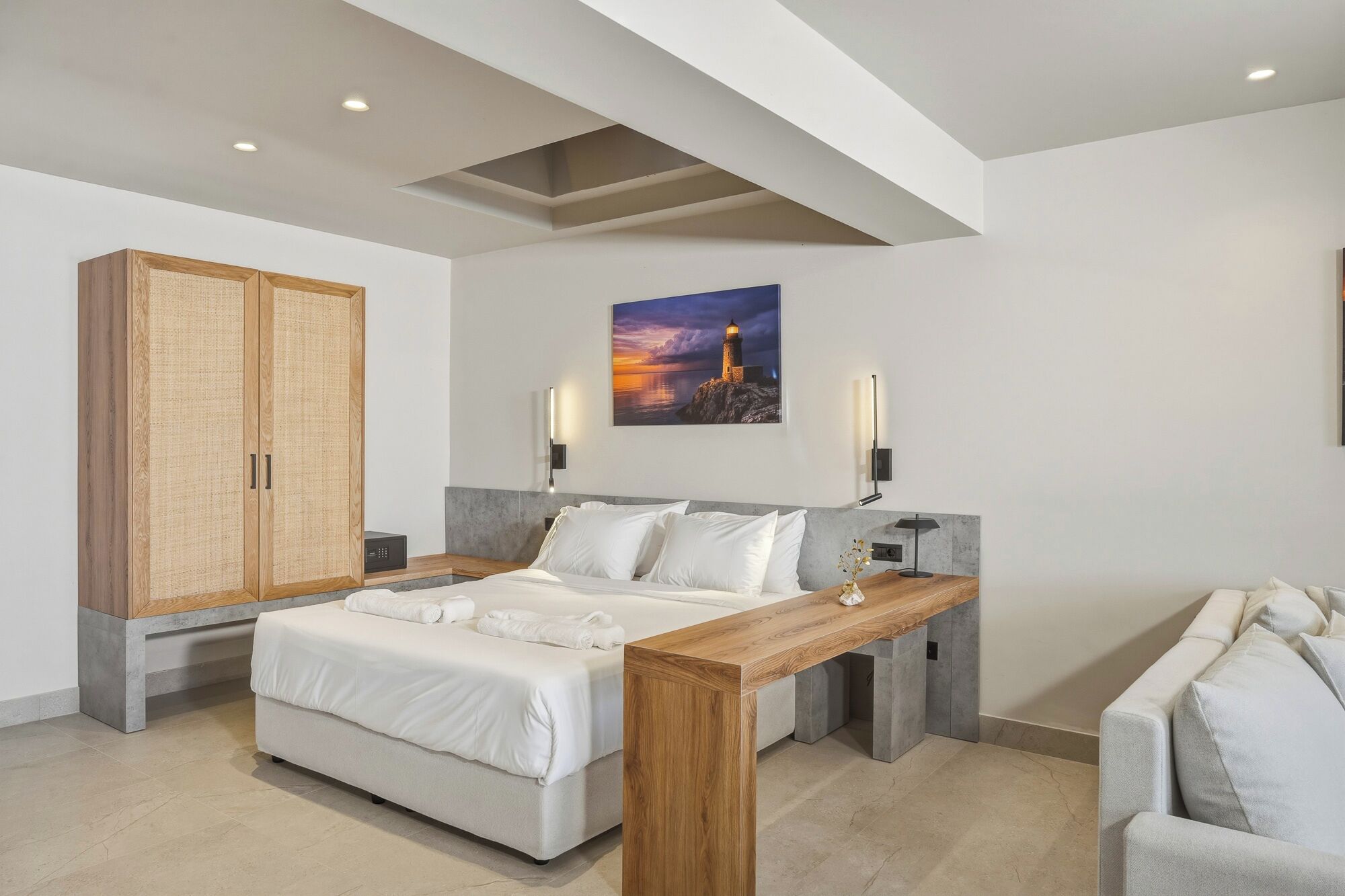 Um quarto moderno com uma cama, um guarda-roupa de madeira, uma mesa de cabeceira, uma escrivaninha e um quadro com um farol.