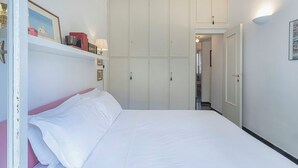 Quarto com uma cama, um guarda-roupa e uma porta.