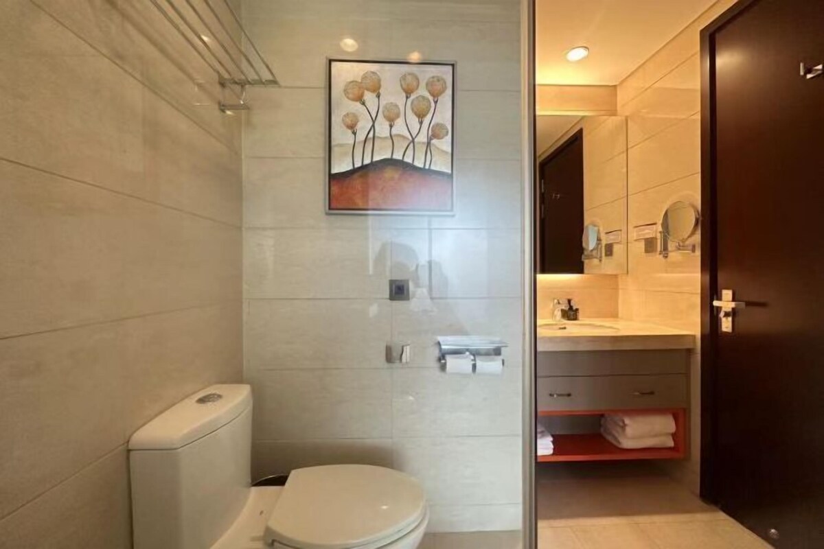 Uma casa de banho moderna com sanita, lavatório e espelho.