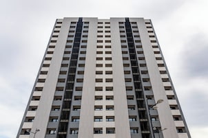 Um edifício alto e moderno, com uma grade de janelas e varandas.