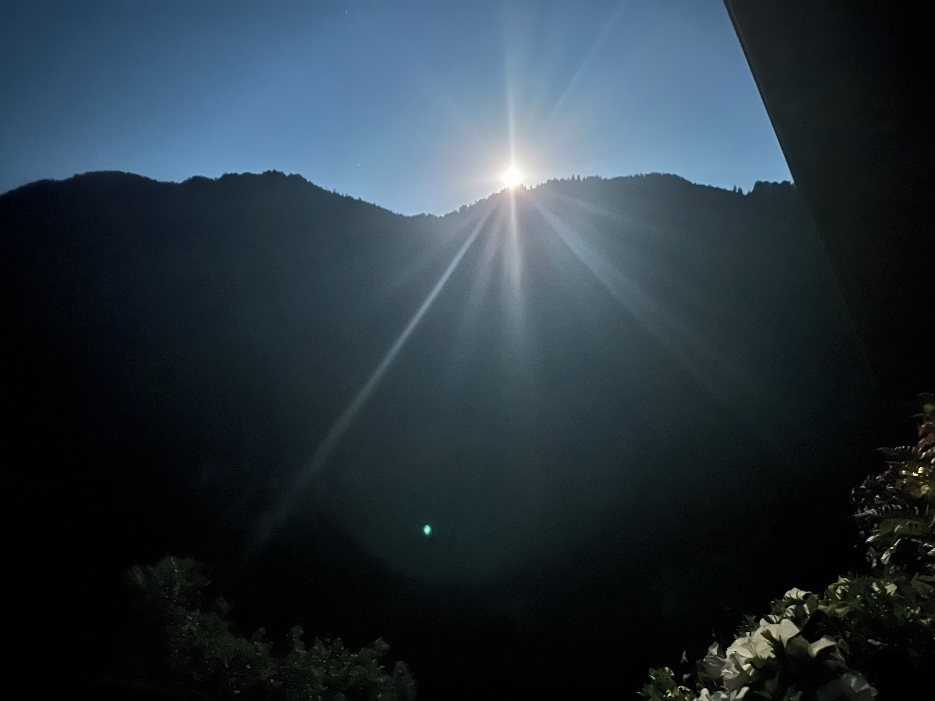 Paisagem de montanha com o sol a brilhar.