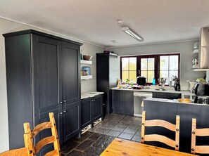 Um frigorífico no espaço comum, um micro-ondas, uma placa de cozinha 