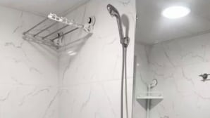 Uma casa de banho com sanita, lavatório e chuveiro.