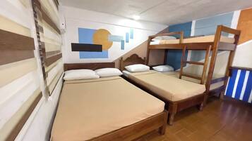 Quarto com beliches, cabeceira de madeira e parede com design geométrico.