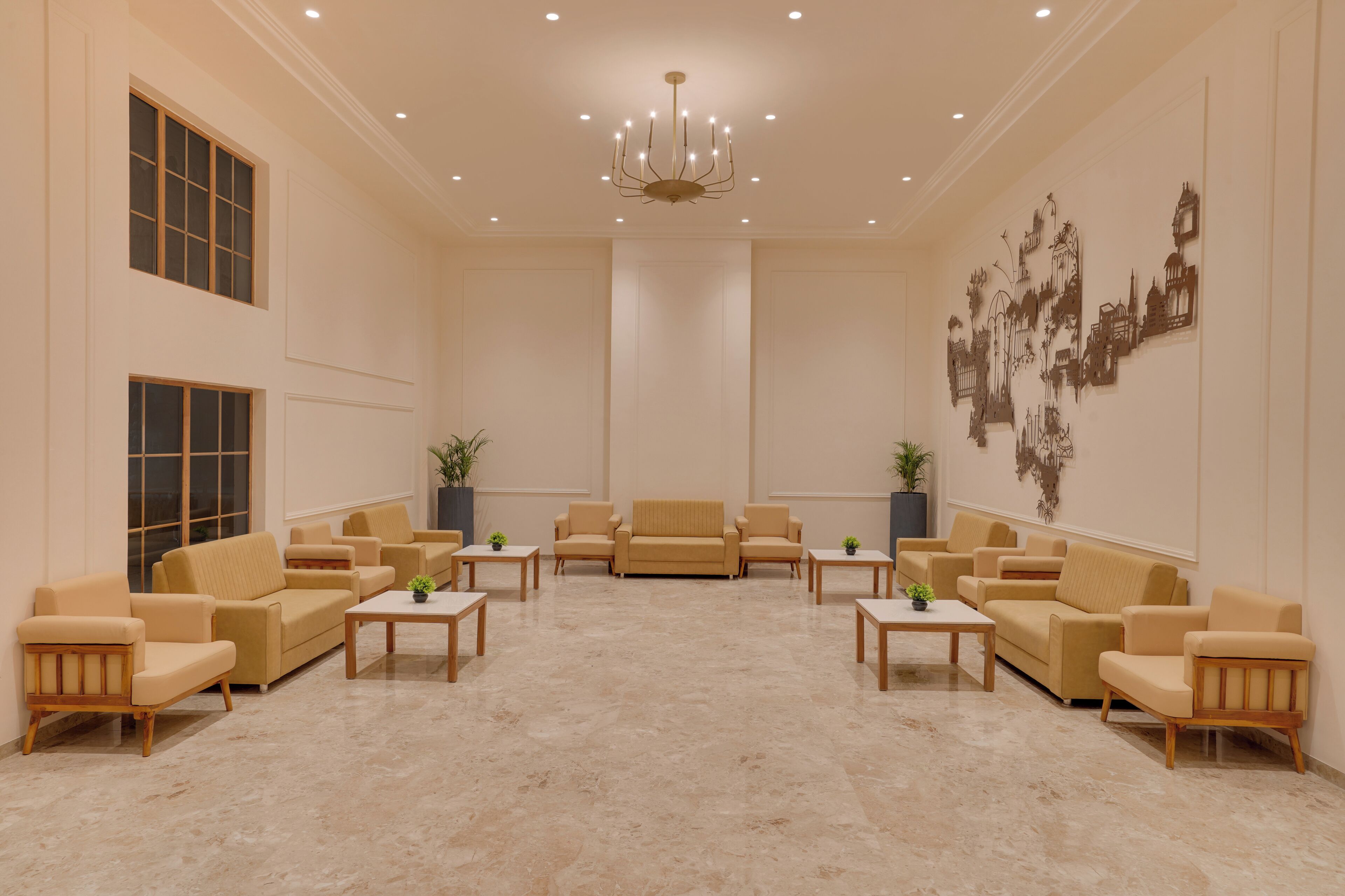 Um hall amplo com teto alto, um candelabro e um grande mural na parede.