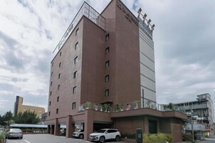 Um hotel com vários andares, um letreiro chamativo, área de estacionamento e design arquitetônico moderno.